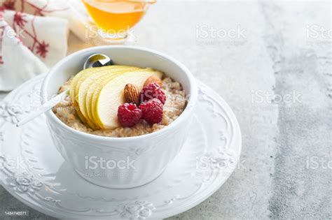 오트밀 회색 콘크리트 오래된 테이블 배경에 라즈베리 배 및 꿀이있는 오트밀 죽 그릇 아침 식사 정상보기 평평한 누워있는 뜨겁고