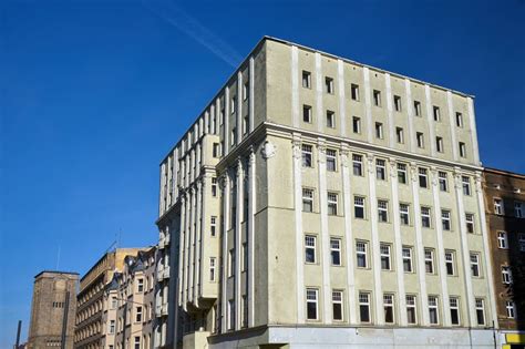 Facade Of A Modernist Buildings And Historic Tower With A Clock In