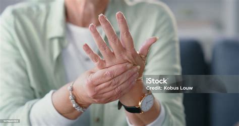 관절염으로 고통스러운 손을 가진 여성 집에서 아픈 관절을 마사지하고 부상 후 손가락에 염증을 일으 킵니다 노인 은퇴하고 성숙한