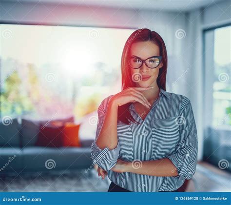 Young Confident Modern Nerd Woman Posing In Living Room In Sunset Stock