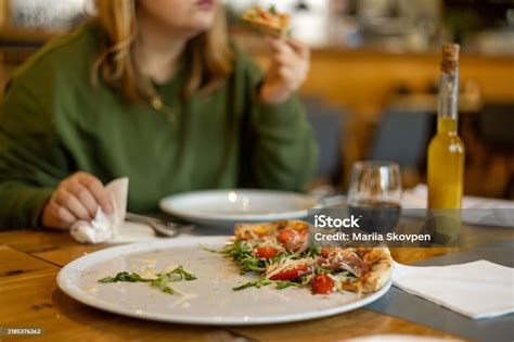 한 여성이 피자 한 조각을 손에 들고 있습니다 피자에 집중하세요 프로슈토 햄 아루굴라 토마토 파마산 치즈를 곁들인 피자 이탈리안 요리 음식 배너 관광객에 대한 스톡 사진 및