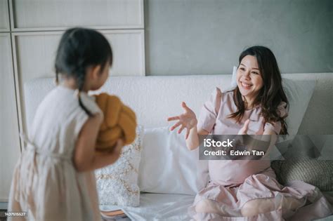 아시아 중국인 임신 한 어머니는 베개를 던지는 침대에서 딸과 놀고 있습니다 어머니에 대한 스톡 사진 및 기타 이미지 어머니 임신 침대 Istock