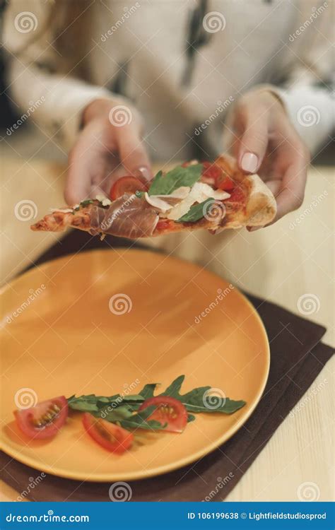 Mujer Que Sostiene El Pedazo De Pizza Italiana En Manos Foto De Archivo