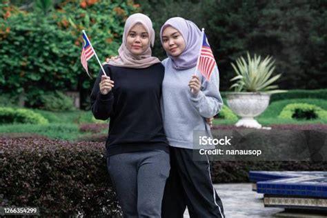 Dua Gadis Melayu Cantik Memegang Bendera Malaysia Di Taman Umum Foto
