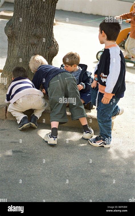 Babes Playing Beside Tree Trunk Stock Photo Alamy