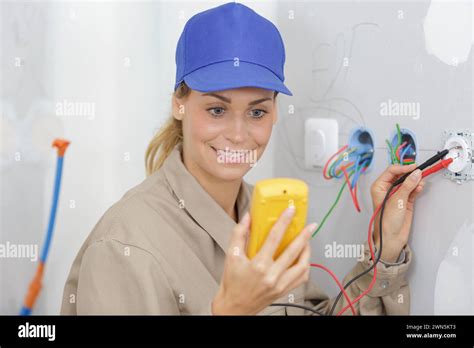 Female Electrician Testing A Wall Socket Stock Photo Alamy