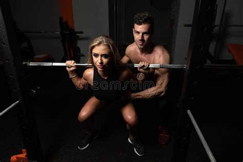 Woman With Personal Trainer At Barbell Squat Stock Image Image Of