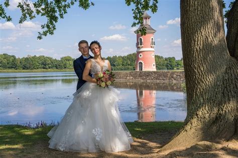 Młoda Piękna Panna Młoda I Pan Młody Stoją Przed Wodą Na Tle Różowej