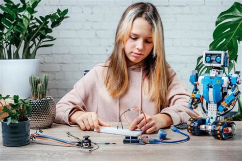A Teenager Girl Plugging Cables To Sensor Chips While Learning Arduino Coding And Robotics Stock