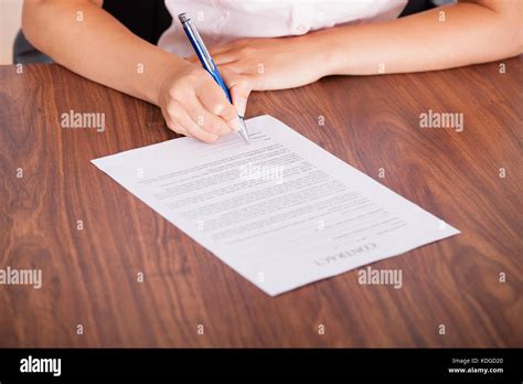Professional Woman Signing Document At Desk Stock Photos Professional Woman Signing Document