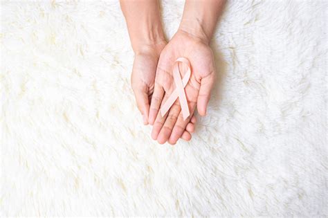 9월 자궁암 인식의 달 살아있는 사람과 질병을 지원하기 위해 복숭아 리본을 들고 있는 여성의 손 헬스케어 및 세계 암의 날 개념