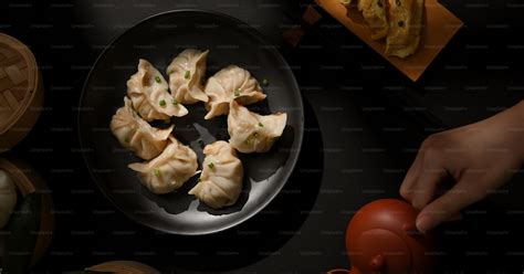 딤섬 만두가 있는 식탁과 중국 식당에서 찻주전자를 가진 여성 손의 상위 뷰 사진 Unsplash의 음식 이미지