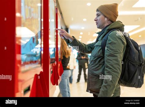Man Interacts With Digital Kiosk In Modern Mall Navigating Touch Screen Technological