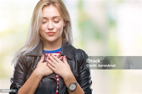 젊은 금발의 여자와 웃 고 고립 된 배경 위에 검은 자 켓을 입고 얼굴에 닫힌된 눈와 감사와 함께 가슴에 손 건강 개념입니다 감사에 대한 스톡 사진 및 기타 이미지 Istock