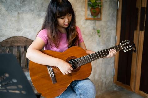 Las manos de una joven feliz tocando la guitarra acústica solo componen