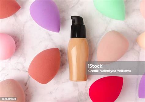 대리석 배경에 뷰티 블렌더와 파운데이션 크림 메이크업 화장품 스폰지 메이크업 제품 아름다움 개념입니다 텍스트를 위한 위치입니다 복사를 위한 공간입니다 플랫 레이 0명에 대한