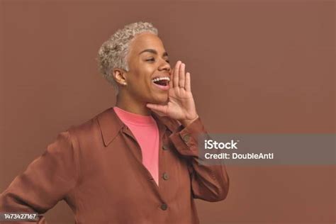 젊은 아름 다운 긍정적 인 아프리카 계 미국인 여자는 스튜디오에 큰 소리로 서 있습니다 갈색에 대한 스톡 사진 및 기타 이미지
