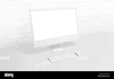 White Computer Display On Work Desk With Brick Wall In Background