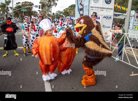 An Entertainer In A Turkey Costume Greets A Brother And Sister In Pumpkin Costumes During A