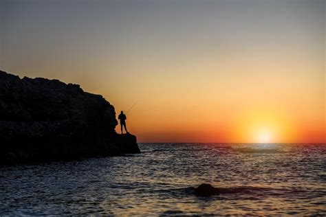 Puesta De Sol En El Mar Y La Silueta De Un Pescador La Silueta De Un