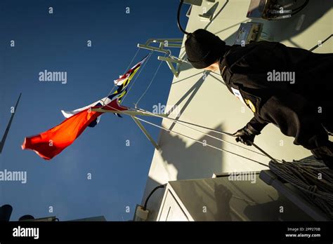 Sailor Raising A Hoist Of Signal Flags Onboard Hmcs Margaret Brooke