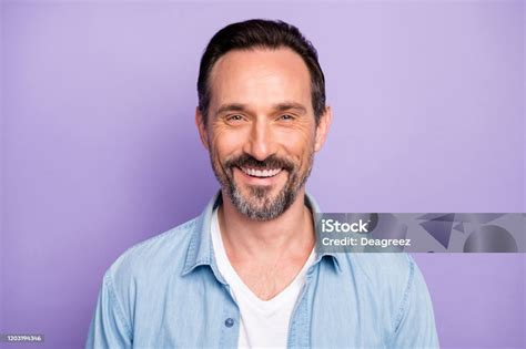 명랑한 솔직한 남자의 사진을 클로즈업 하여 보라색 배경 위에 고립 된 그의 가족 착용 데님 청바지 의류와 함께 재미를 보입니다 갈색 머리에 대한 스톡 사진 및 기타 이미지