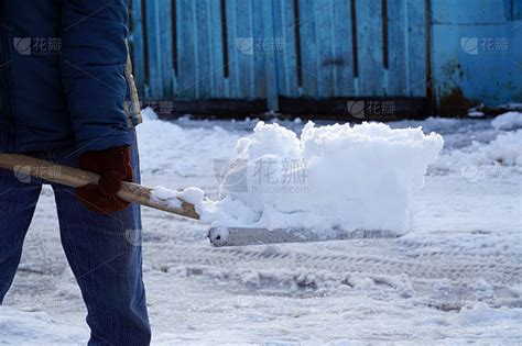 男人在院子里清理雪铲