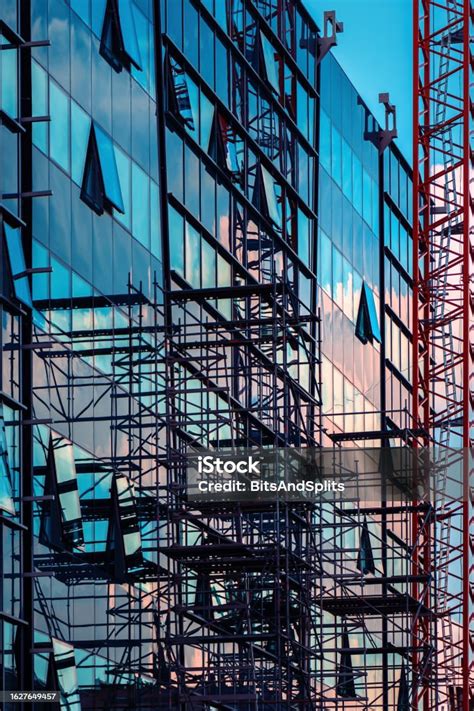 유리 외관이 있는 현대적인 사무실 건물의 재건축 비계가 있는 건설 현장 및 추상적인 기하학적 패턴을 형성하는 크레인 사무실에 대한 스톡 사진 및 기타 이미지 Istock