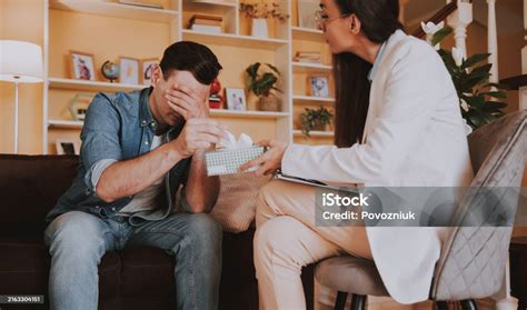 우울증의 심리 치료 치료 정신 건강 클리닉 사무실에서 남성 환자와 세션을 가진 여성 심리학자 의사는 회의 중에 몇 가지 메모를 씁니다 절박한 상황에 처한 심리적 도움 30