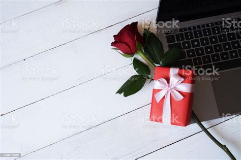 빨간 장미와 빨간 선물 상자와 흰색 나무 배경에 노트북이 있습니다 발렌타인 데이 결혼식 생일 및 특별한 날 개념 텍스트 공간을
