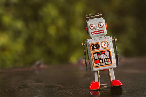 빈티지 장난감 로봇 와 다채로운 단추 와 다이얼 표면 위에 서 있는 로봇은 장난기 넘치는 표정을 가지고 있어 향수와 매력을 불러일으킵니다 로봇에 대한 스톡 사진 및 기타