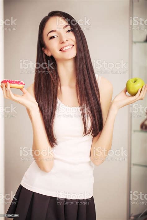 다이어트입니다 젊은 여자는 비늘 고 사과 도넛 사이 선택에 피자를 들고 건강 한 식 생활의 개념 건강관리와 의술에 대한 스톡 사진 및 기타 이미지 Istock