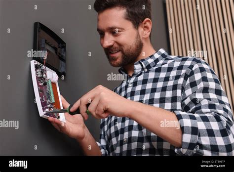 Man Installing Home Security Alarm System On Gray Wall Stock Photo Alamy