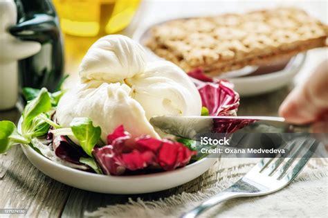 얇게 썬 부라토 치즈와 샐러드를 흰 접시에 얹습니다 롤로 로소 양상추 크레스 샐러드 및 기타 녹색 허브 체중 감량을 위한 건강한 식단의 개념 이탈리아 요리 선택적 초점 0