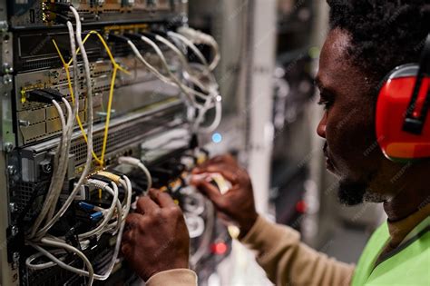 Premium Photo Technician Setting Up Network In Server Room And Wearing Ear Protection