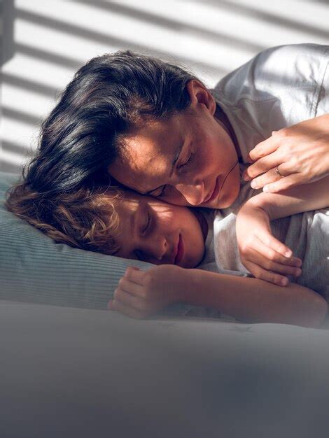 Terna mãe e filho dormindo na cama Foto Premium
