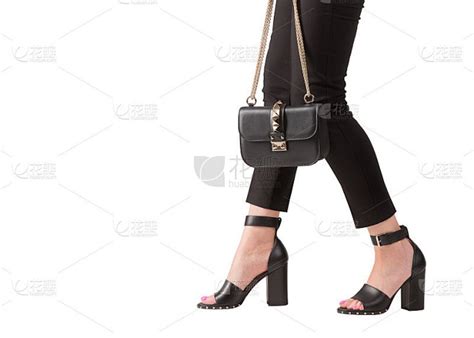 穿裤子的女孩穿着高跟鞋走路。