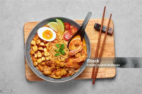 콘크리트 테이블 상단에 회색 그릇에 락사 코코넛 국수 수프와 닭고기 페라나칸 요리의 새우 아시아 음식 프론 해산물에 대한 스톡