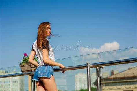 Girl In Denim Shorts On The Balcony Mini Denim Shorts Woman In A