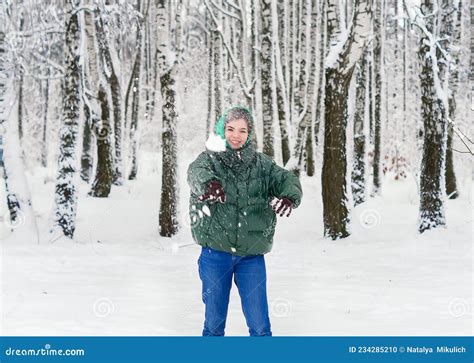 Una Encantadora Joven Lanza Bolas De Nieve En El Invierno En El Bosque