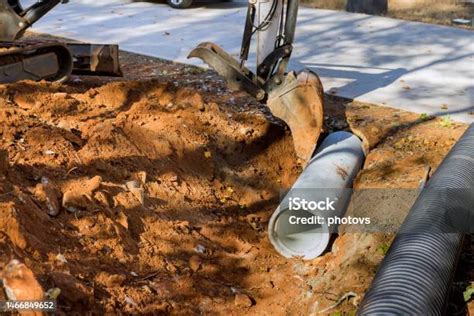 하수관을 지하로 몰기 위해 트랙터 리프트를 운영하는 직원이 지하 콘크리트 배관을 설치할 준비를 하고 있습니다 하수에 대한 스톡 사진 및 기타 이미지 Istock