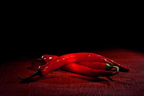 고추가 닫힙 칠레 고추 나무 보드에 붉은 배경에 야채 극적인 빛을 예술적 효과로 대조합니다 후추 근처의 텍스트를 위한 공간과 여유 공간을 복사합니다 건강한 식생활에 대한