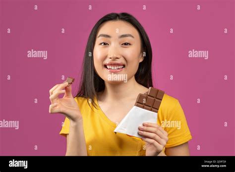 Happy Korean Lady Eating Chocolate Enjoying Yummy Dessert And Smiling