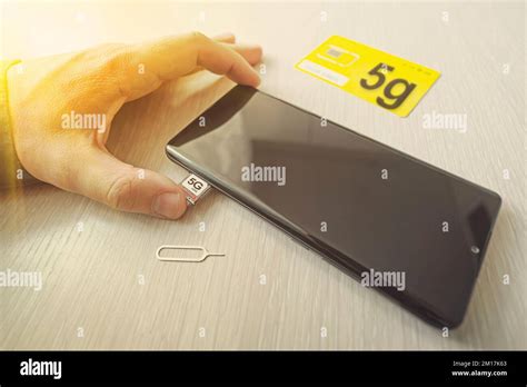 SIM Card Labeled 5g Replacing A SIM Card In A Mobile Phone With High Speed Internet Stock Photo