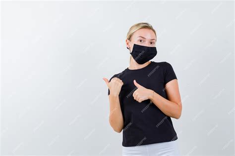 고립 된 엄지 옆으로 가리키는 금발 아가씨의 초상 무료 사진