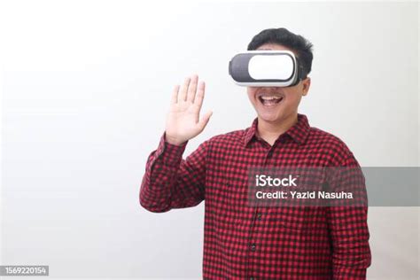 빨간 격자 무늬 셔츠를 입은 아시아 남성의 초상화는 가상 현실 안경을 쓰고 게임 안에서 열린 손바닥으로 친구를 맞이합니다 흰색