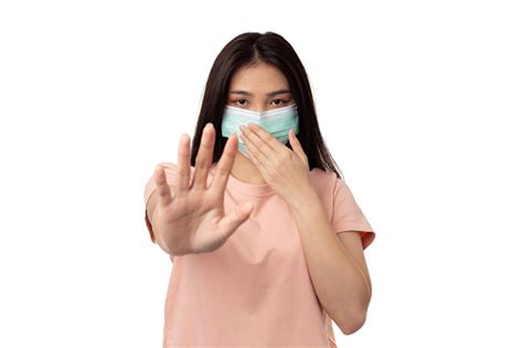 의료 용 마스크를 착용한 아시아 여성은 코로나 바이러스 기호를 들고 집에 머물지 말고 흰색 배경에 고립 된 분홍색 셔츠를 입은