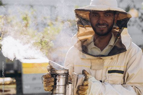 Happy Smiling Indian Male Beekeeper Smoking Honey Bees With Bee Smoker