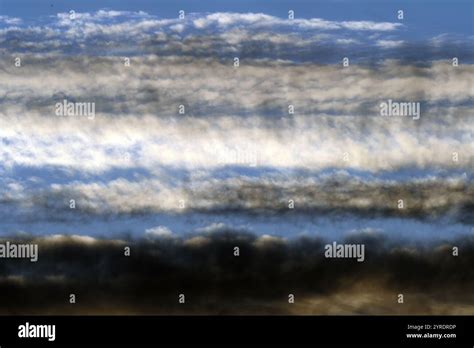 High Cirrus Clouds Lit From A Low Sun Are Arranged In Ethereal Plains