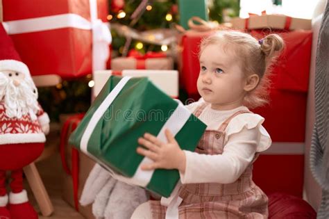 Adorable Caucasian Girl Holding T Sitting On Floor By Christmas Tree